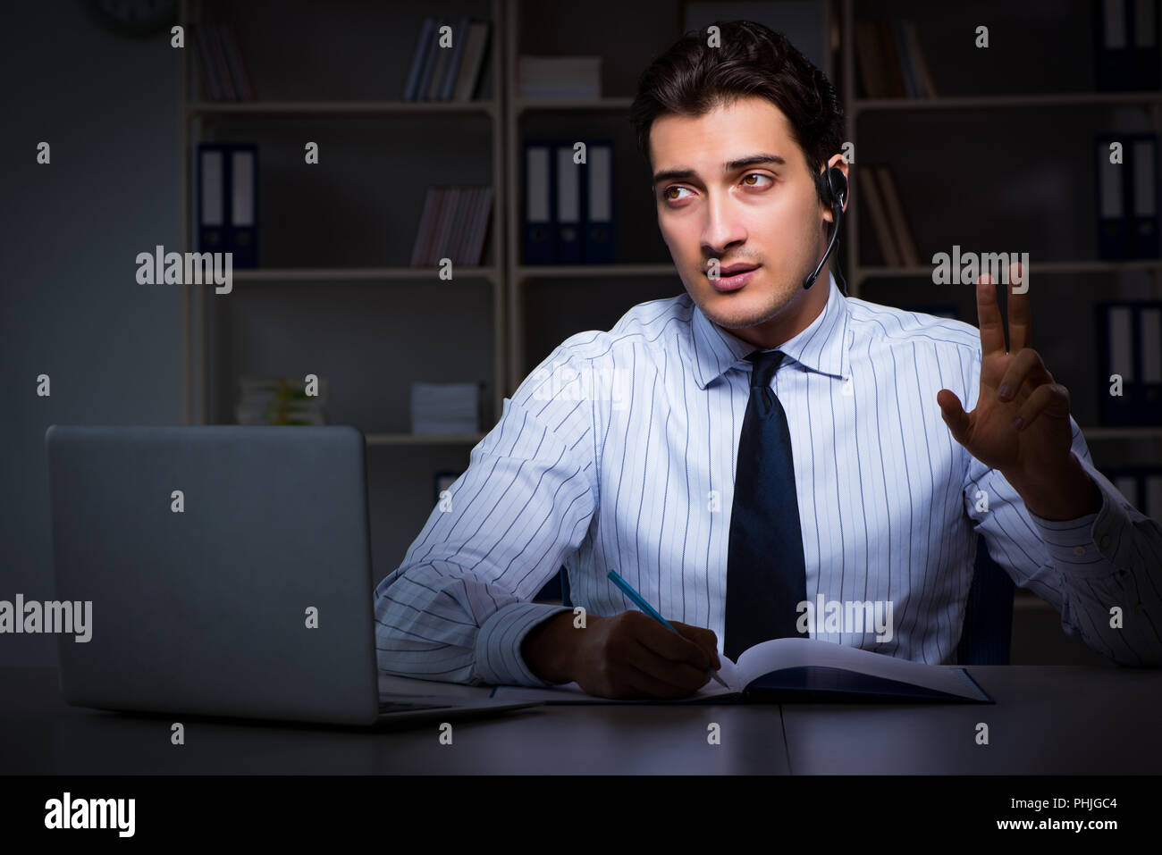 Call center operator talking to customer during night shift Stock Photo ...