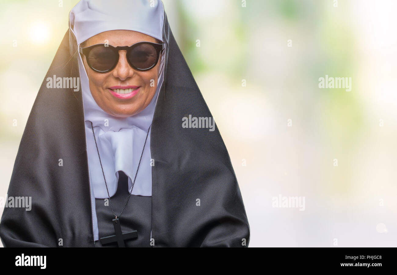 Middle age senior catholic nun woman wearing sunglasses over isolated ...