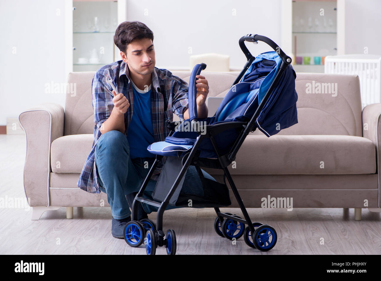 Young father assembling baby pram at home Stock Photo - Alamy