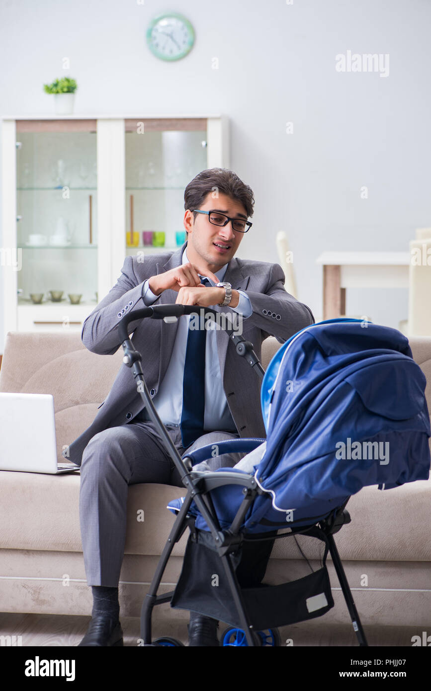 Businessman looking after newborn baby at home and teleworking Stock ...