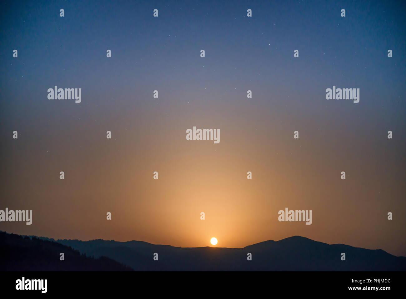 Moon rising on night sky Stock Photo - Alamy