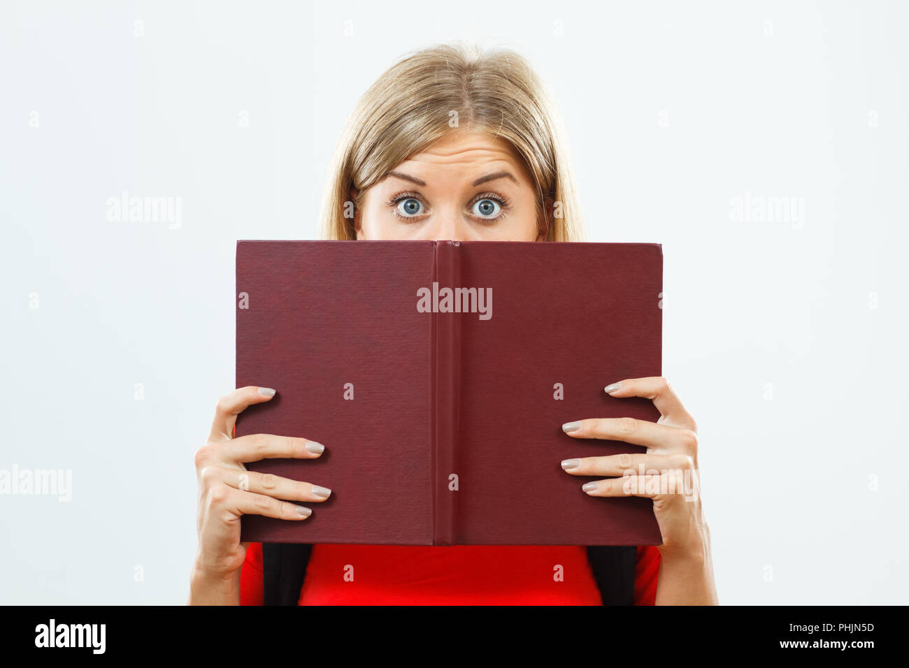Schoolgirl hiding behind book hi-res stock photography and images - Alamy