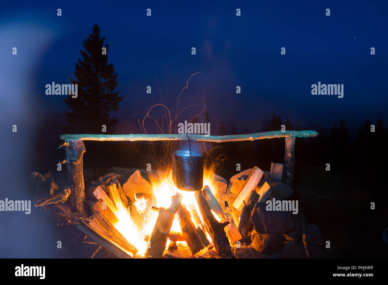 Cooking food in the pot on fire Stock Photo - Alamy