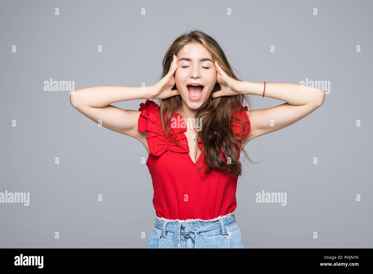 Portrait of frustrated angry woman screaming out loud and pulling her ...