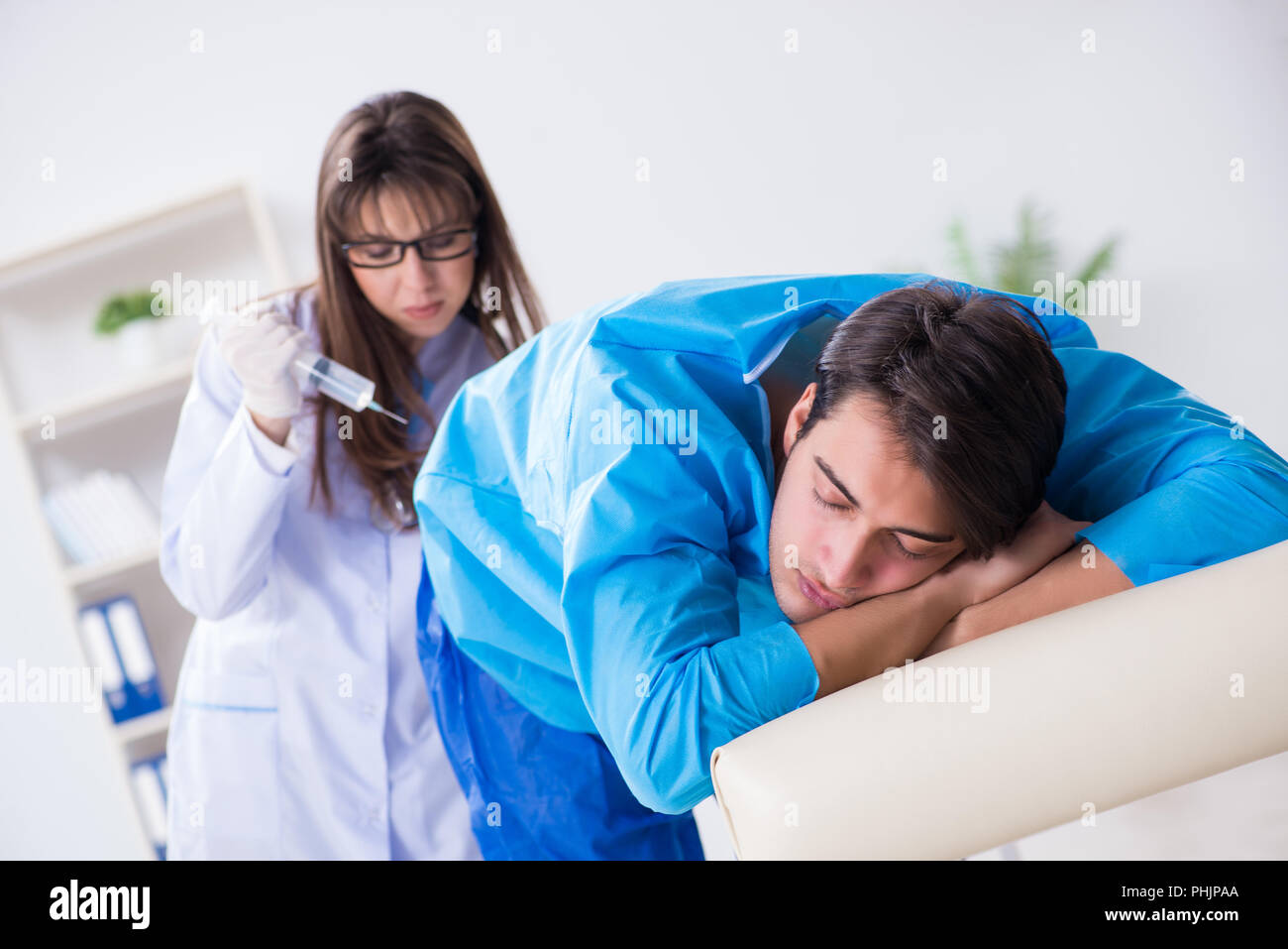 Funny man getting ready for buttocks syringe shot Stock Photo - Alamy