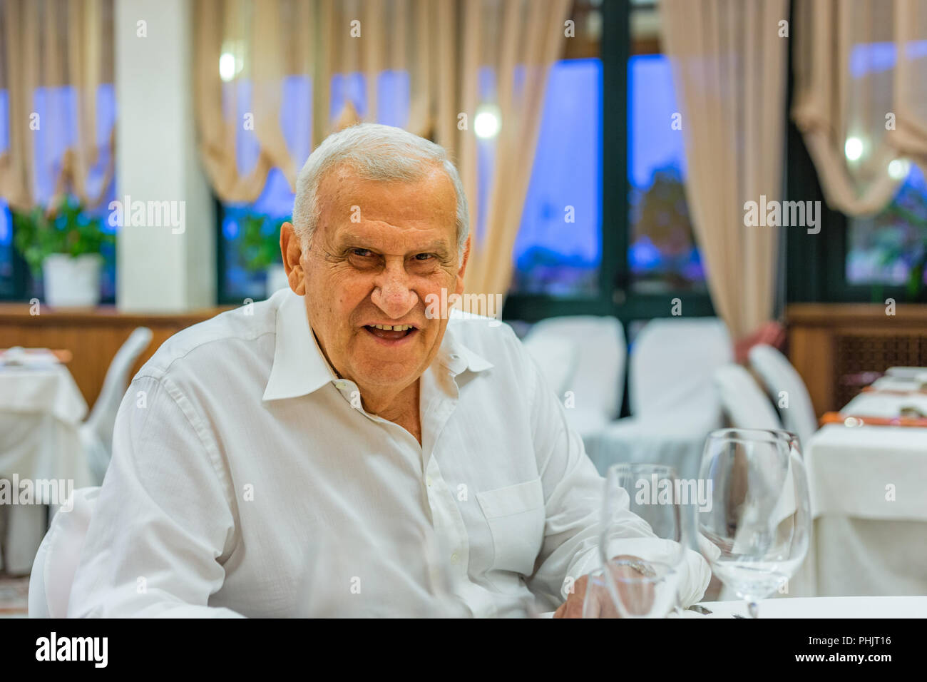 Old man is smiling while having dinner at Italian restaurant Stock ...