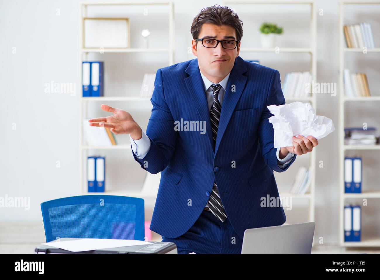 Businessman angry at copying machine jamming papers Stock Photo - Alamy