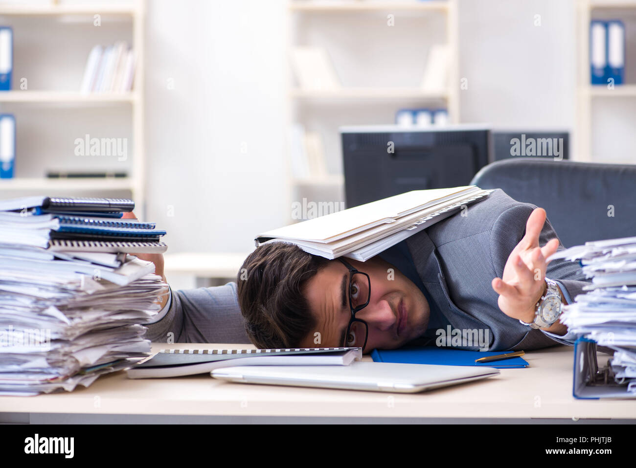 Overloaded with work employee under paperwork burden Stock Photo - Alamy
