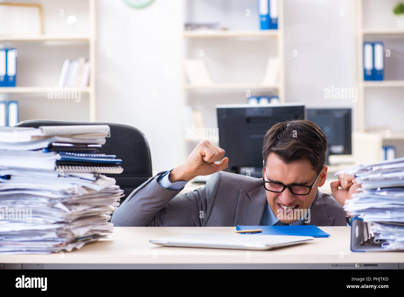 Overloaded with work employee under paperwork burden Stock Photo - Alamy
