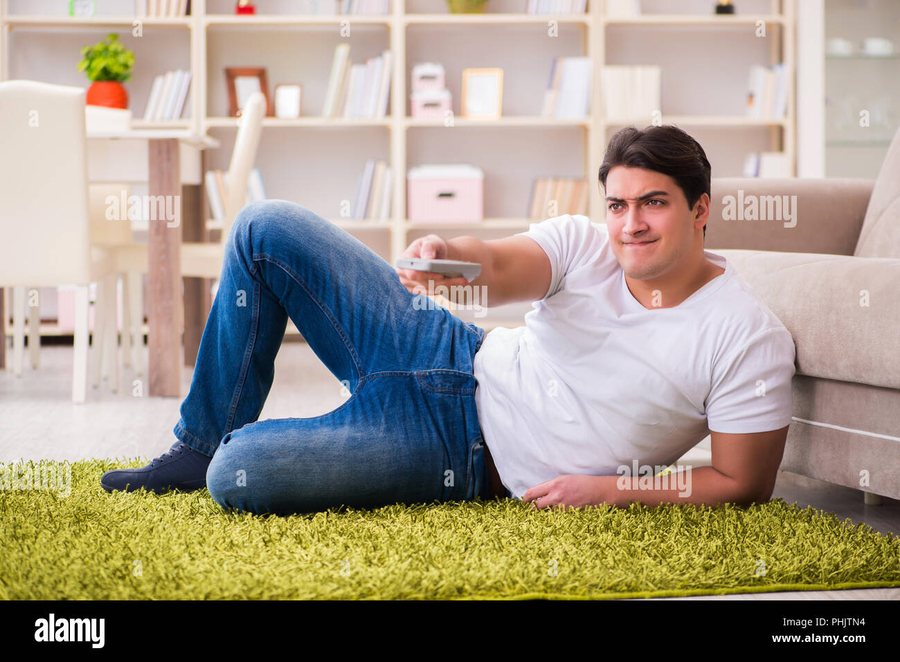 Man watching tv at home on floor Stock Photo - Alamy