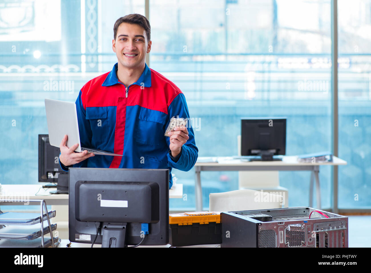 Computer technician repairing broken computer in workshop Stock Photo ...