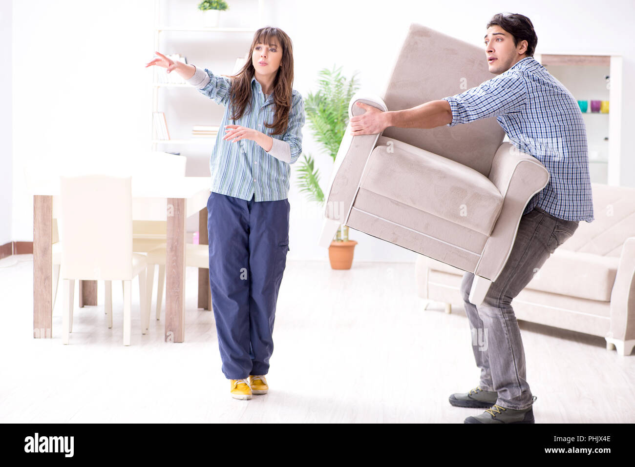 Man moving armchair in the living room Stock Photo - Alamy