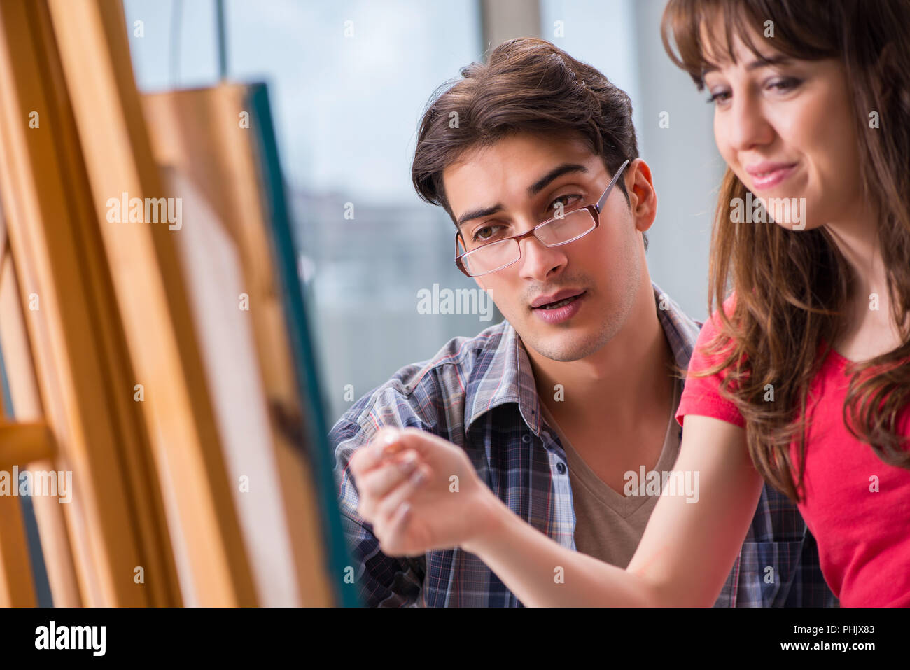 Artist coaching student in painting class in studio Stock Photo - Alamy