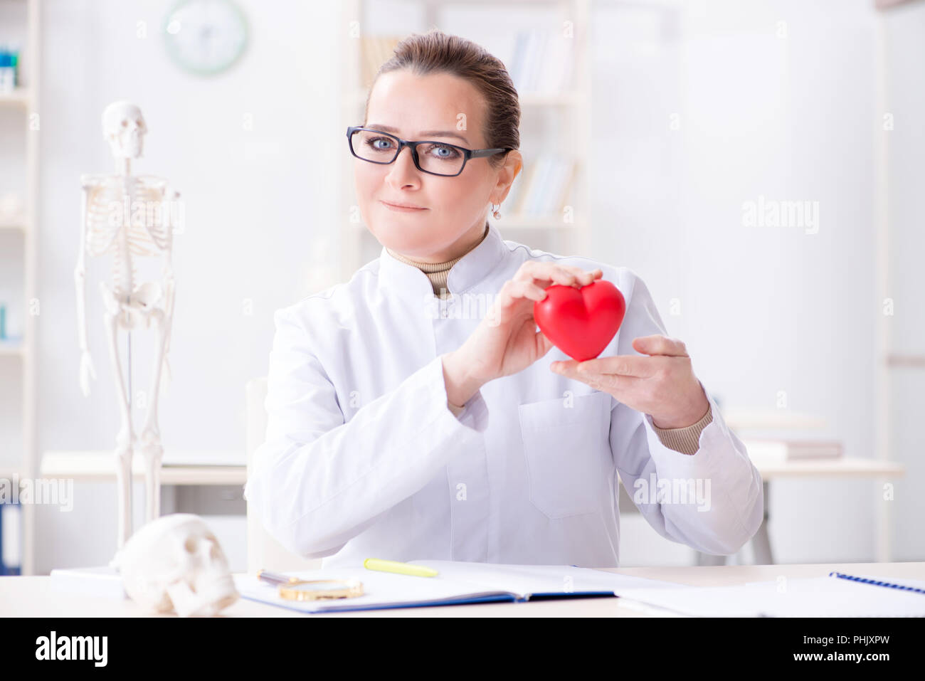 Cardiologist with red heart in medical concept Stock Photo - Alamy