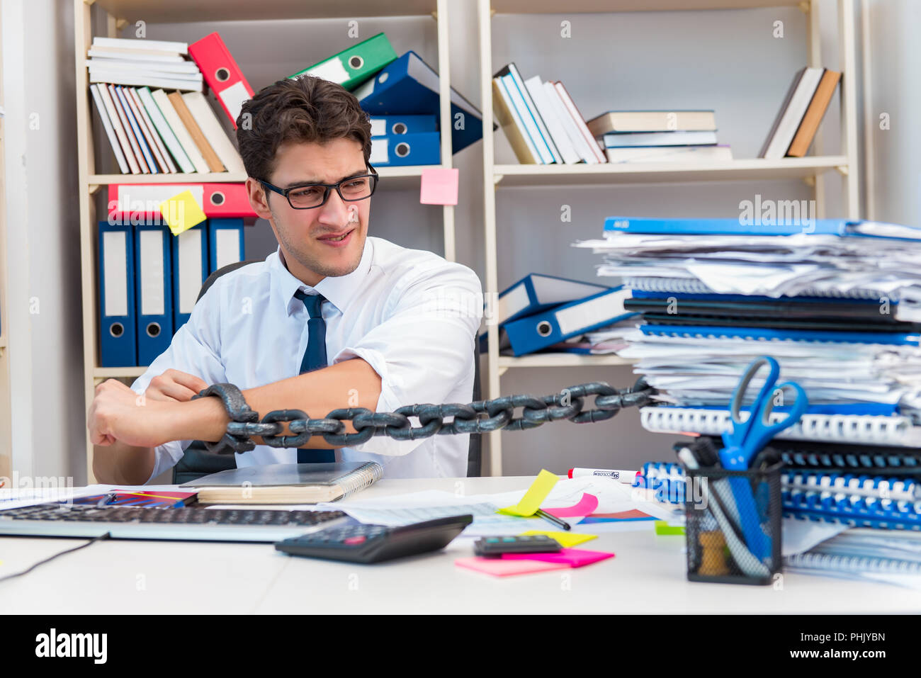 Employee attached and chained to his desk with chain Stock Photo - Alamy
