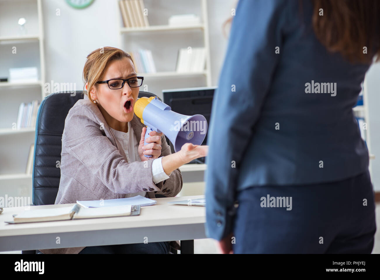 Angry woman boss yelling at her female employee Stock Photo - Alamy
