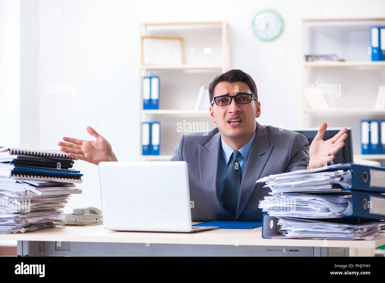 Overloaded with work employee under paperwork burden Stock Photo - Alamy