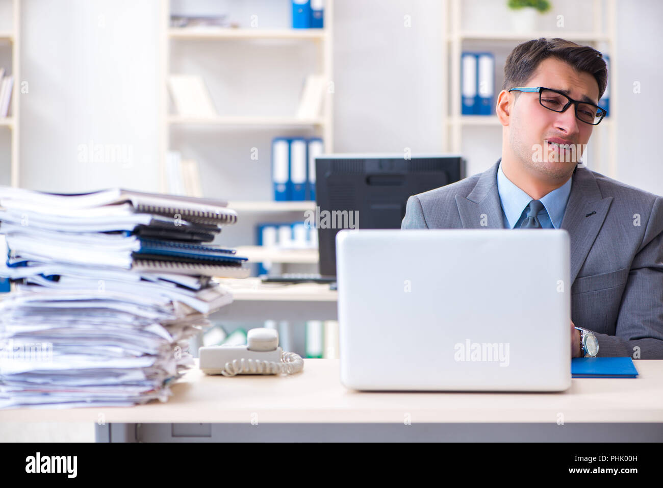 Overloaded with work employee under paperwork burden Stock Photo - Alamy