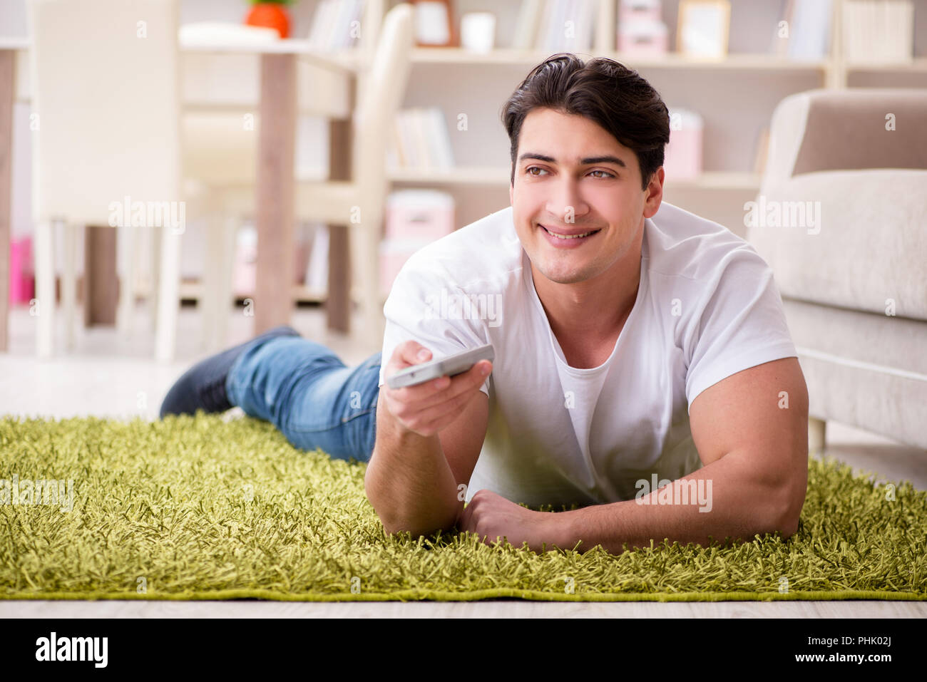 Man watching tv at home on floor Stock Photo - Alamy