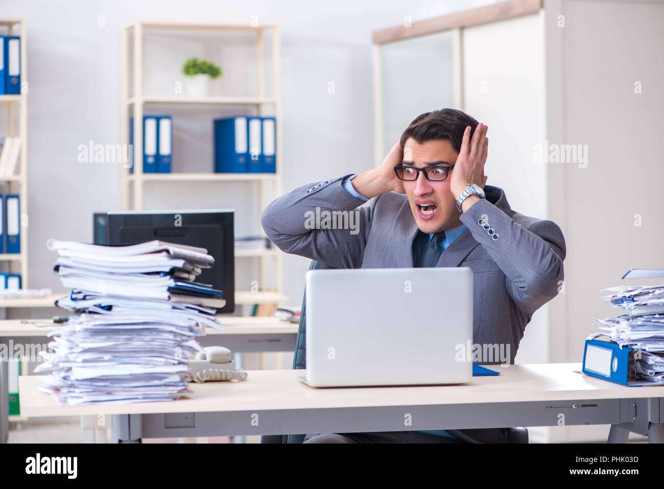 Overloaded with work employee under paperwork burden Stock Photo - Alamy