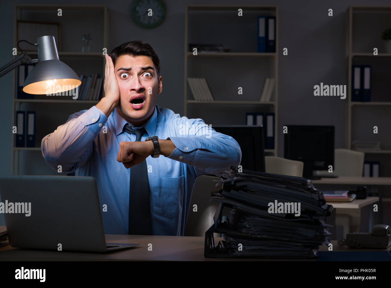 Employee working late at night at important report Stock Photo - Alamy