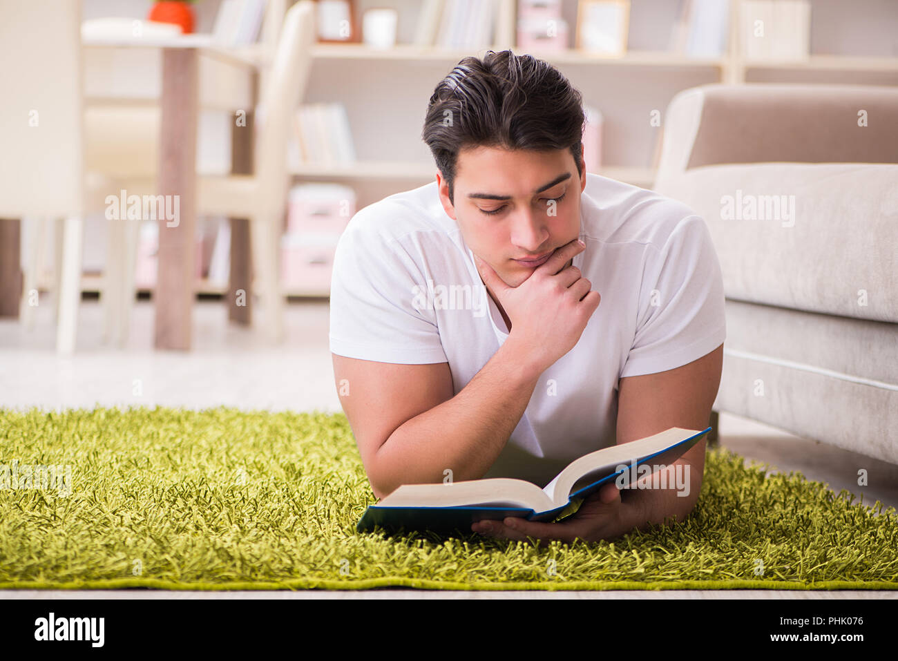 Man reading book at home on floor Stock Photo - Alamy