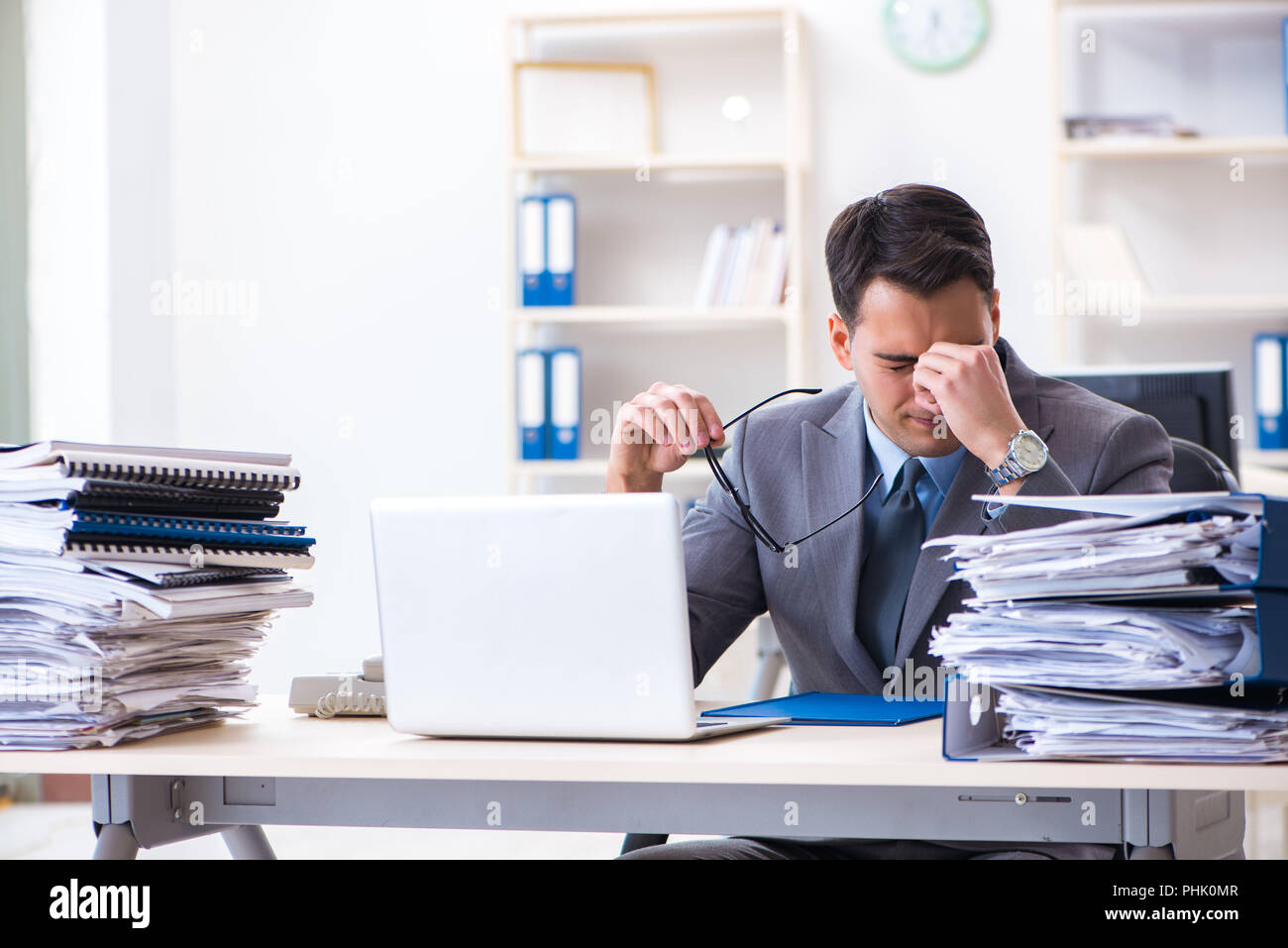 Overloaded with work employee under paperwork burden Stock Photo - Alamy