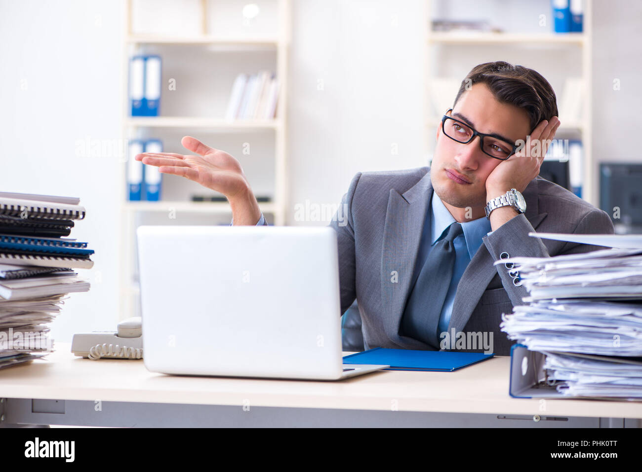 Overloaded with work employee under paperwork burden Stock Photo - Alamy