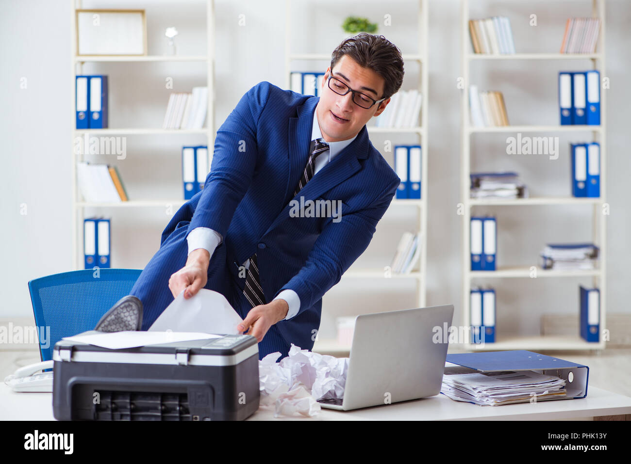 Businessman angry at copying machine jamming papers Stock Photo - Alamy