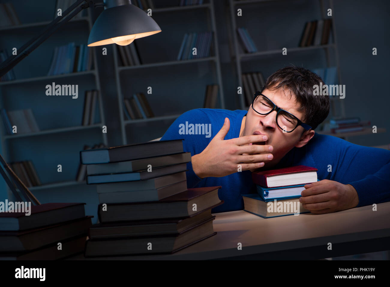 Student preparing for exams late at night in library Stock Photo - Alamy