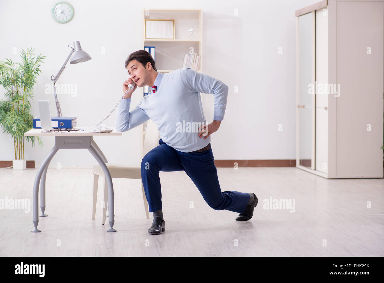 Employee doing stretching exercises in the office Stock Photo - Alamy