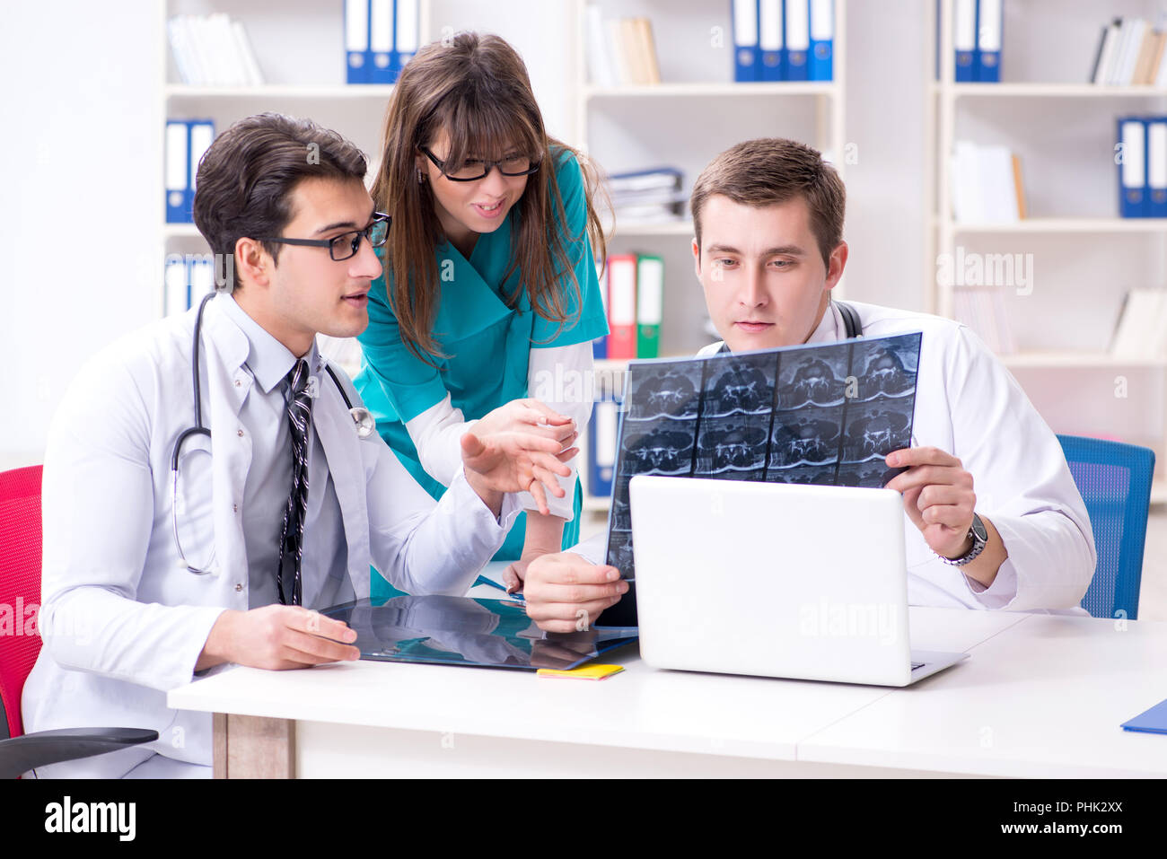 Three doctors discussing scan results of x-ray image Stock Photo - Alamy