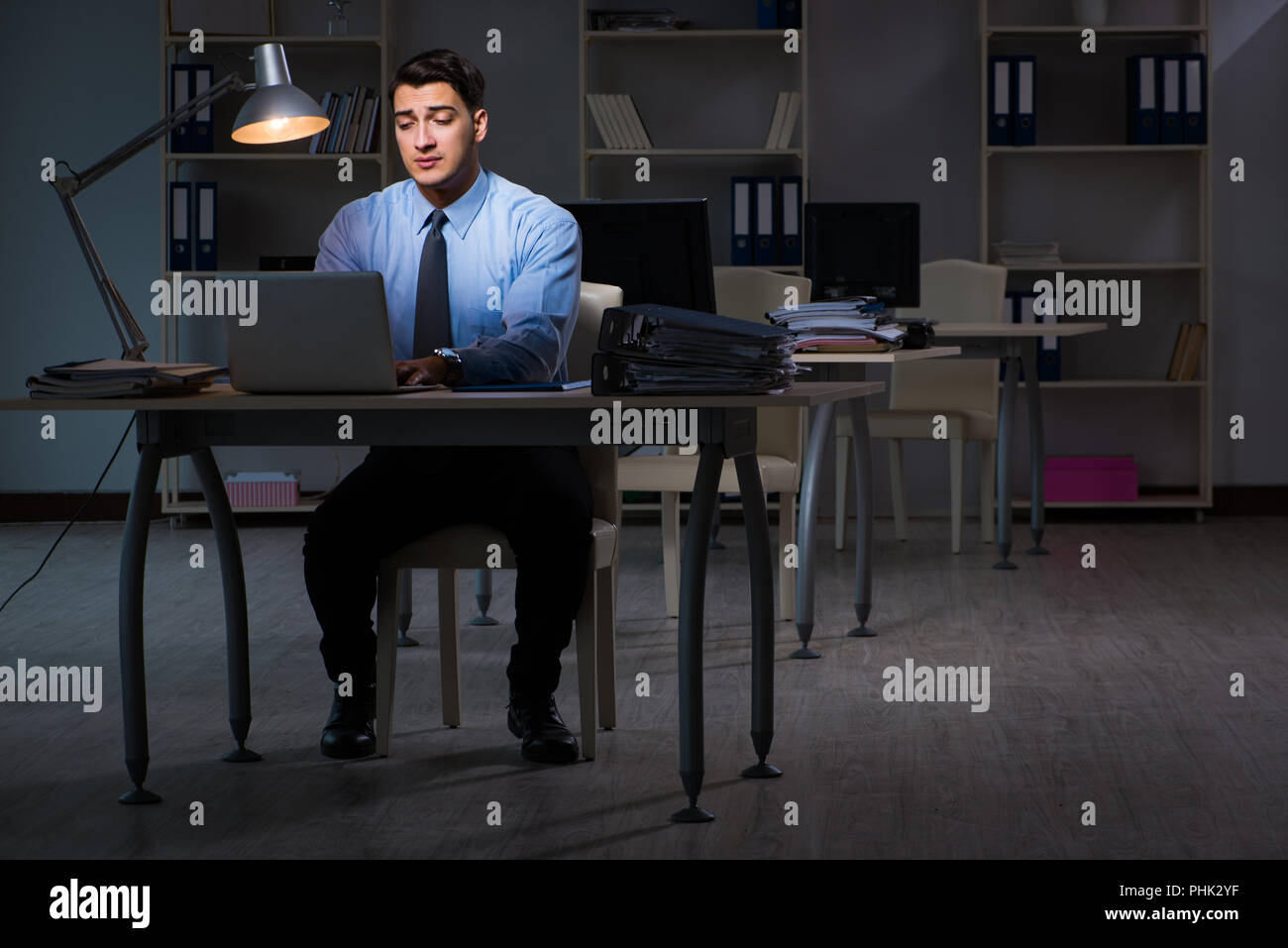 Employee working late at night at important report Stock Photo - Alamy