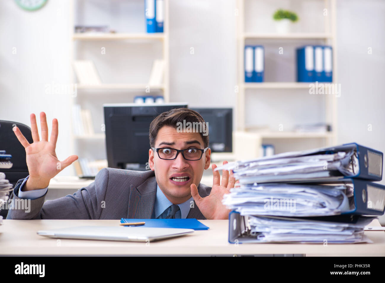 Overloaded with work employee under paperwork burden Stock Photo - Alamy