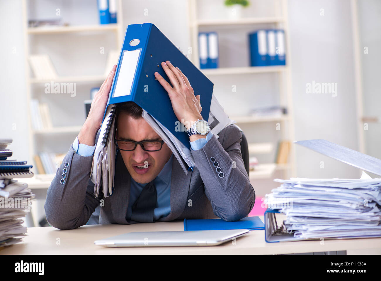 Overloaded with work employee under paperwork burden Stock Photo - Alamy