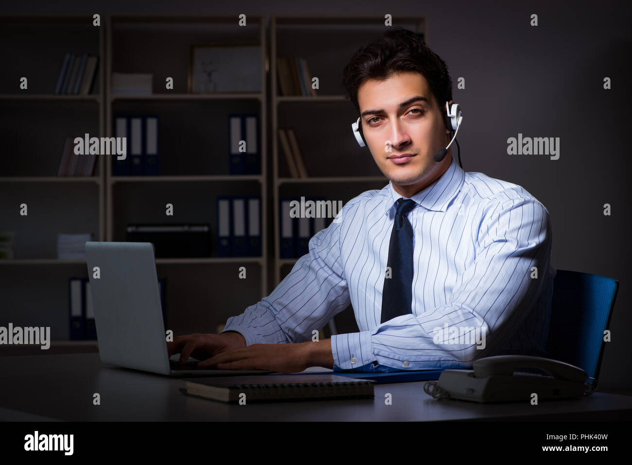 Call center operator talking to customer during night shift Stock Photo ...