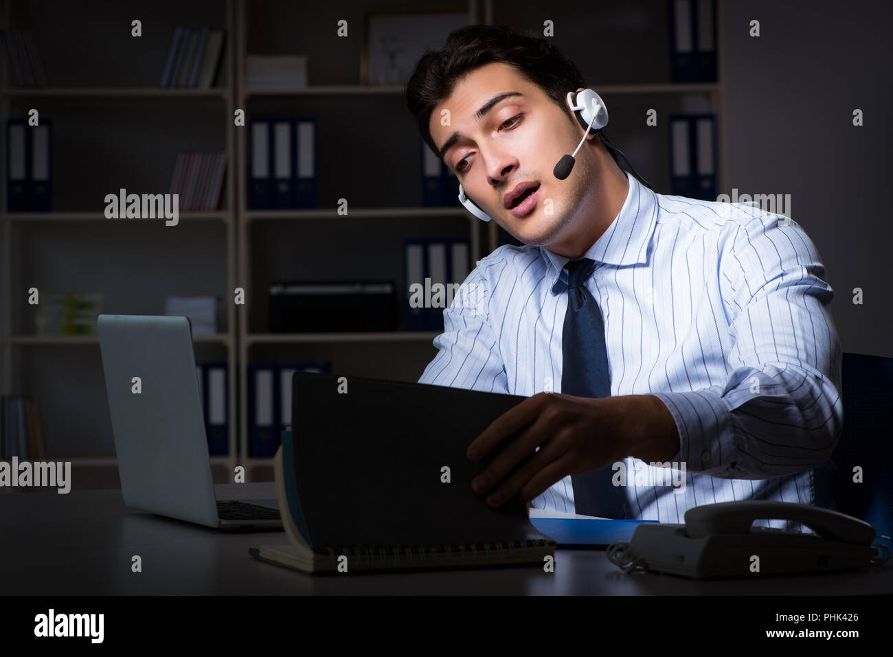 Tired and exhausted helpdesk operator during night shift Stock Photo ...