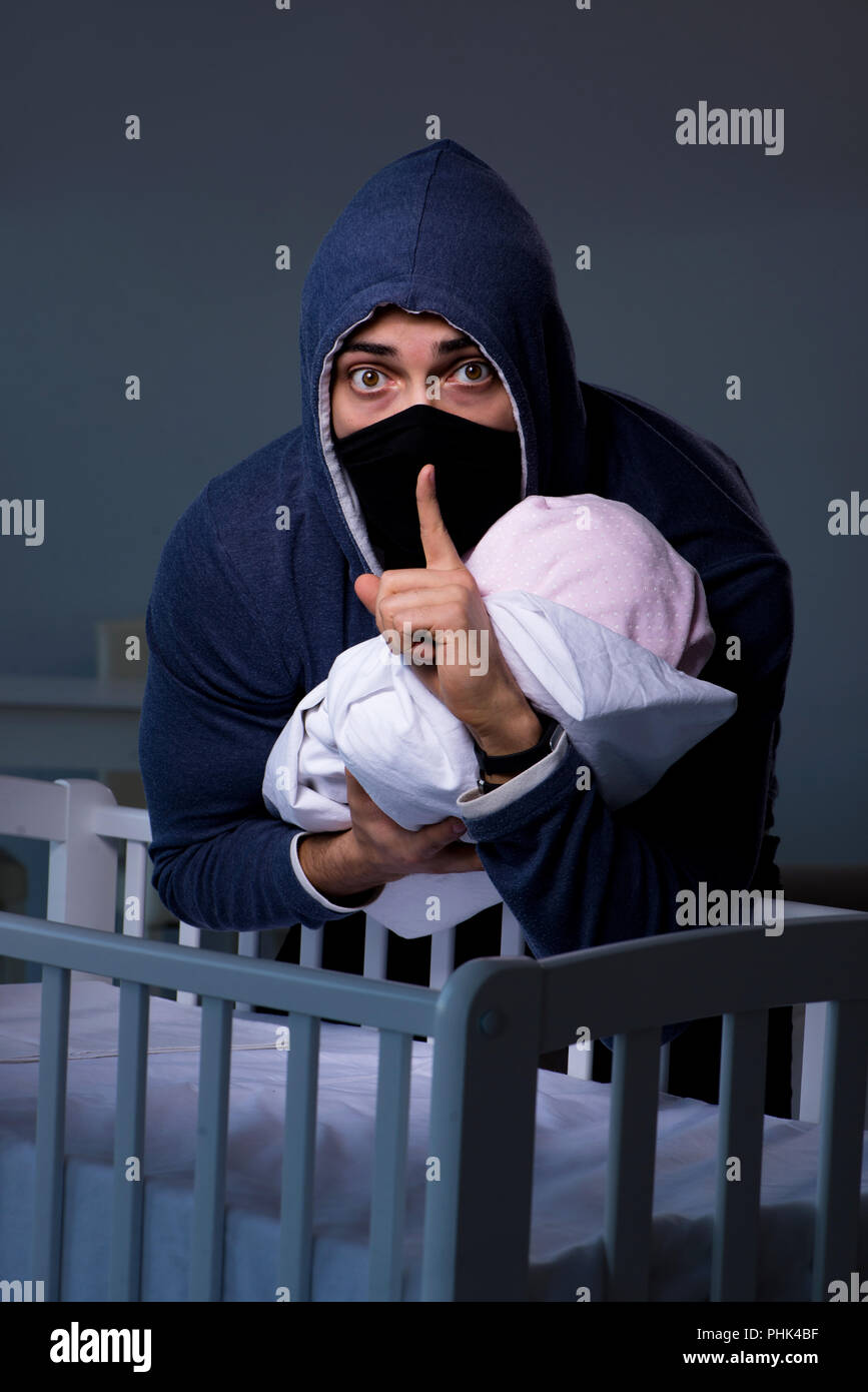 Criminal stealing baby in human child traficking concept Stock Photo ...