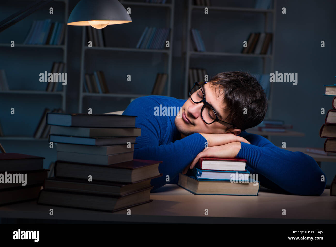 Student preparing for exams late at night in library Stock Photo - Alamy