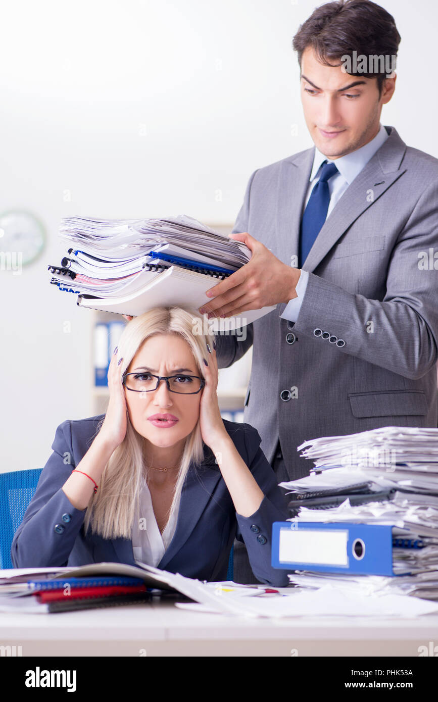 Boss bringing additional work to his assistant secretary Stock Photo ...
