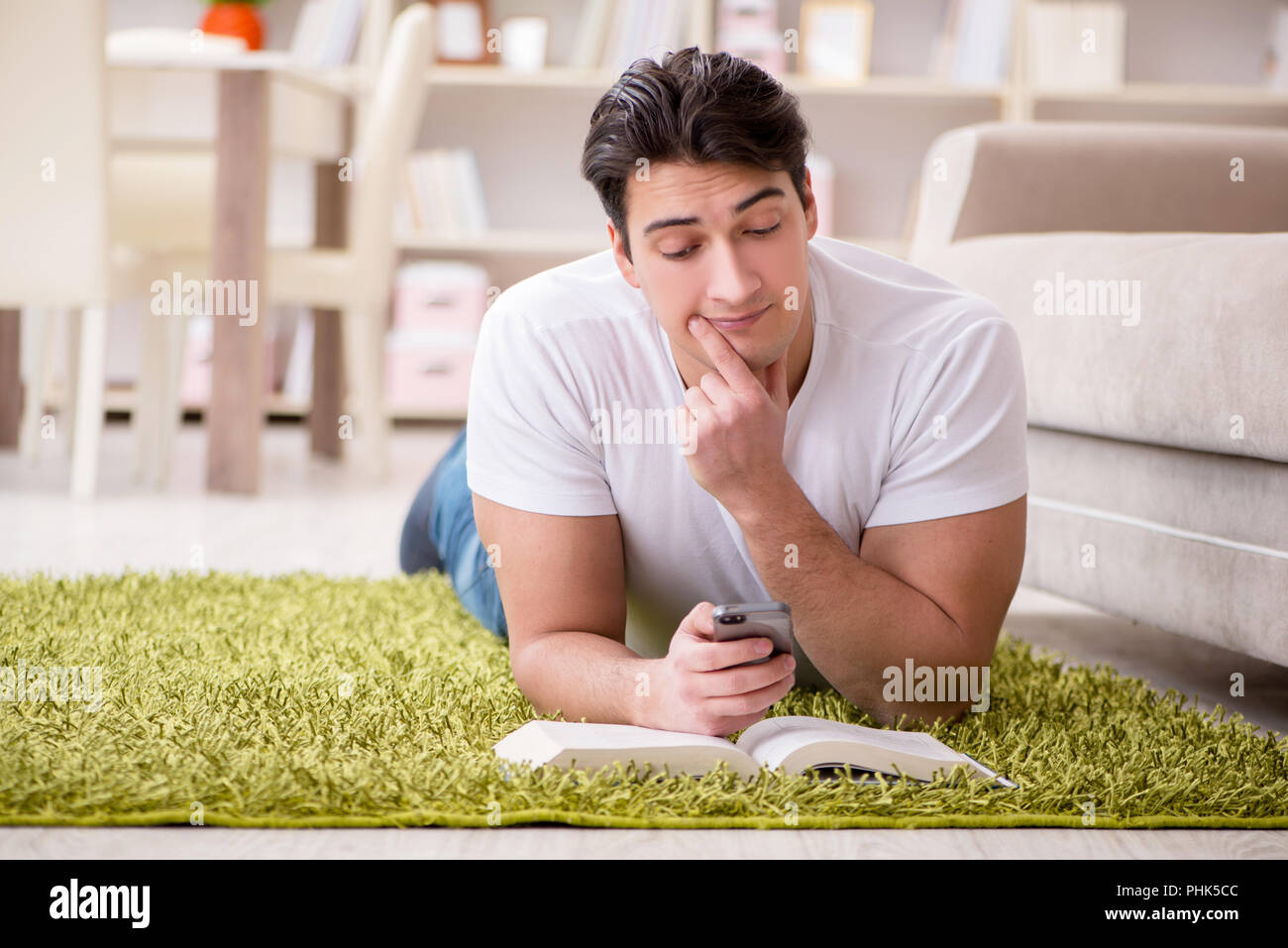 Man reading book at home on floor Stock Photo - Alamy