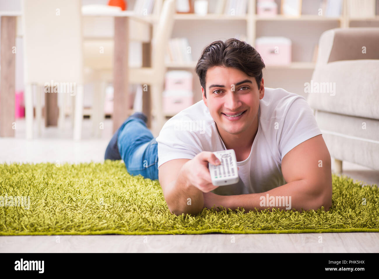 Man watching tv at home on floor Stock Photo - Alamy