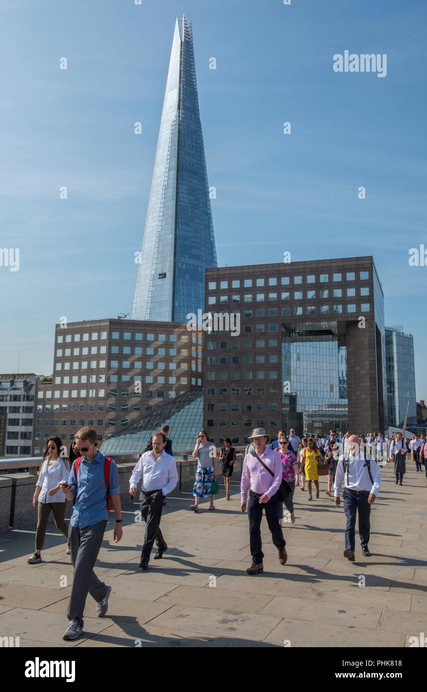 commuters walking across london bridge on a summers day with blue sky ...