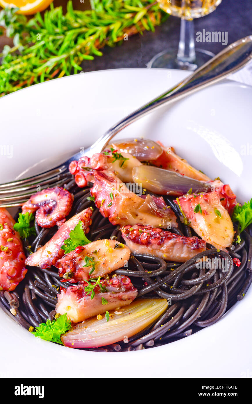 octopus with black spaghetti and garlic sauce Stock Photo - Alamy