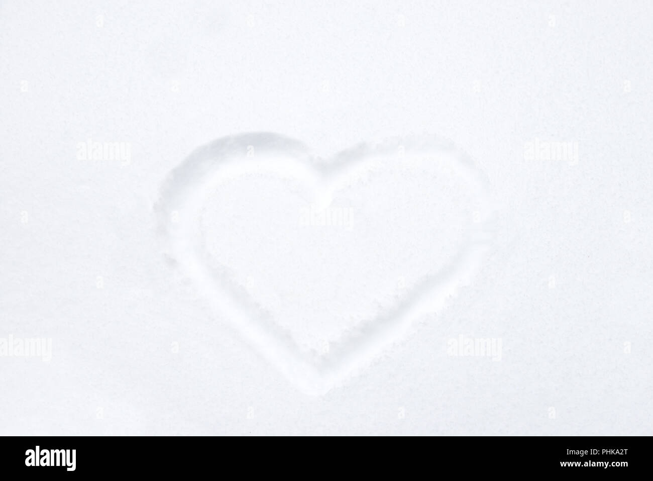 Heart shape drawing on white snow Stock Photo - Alamy