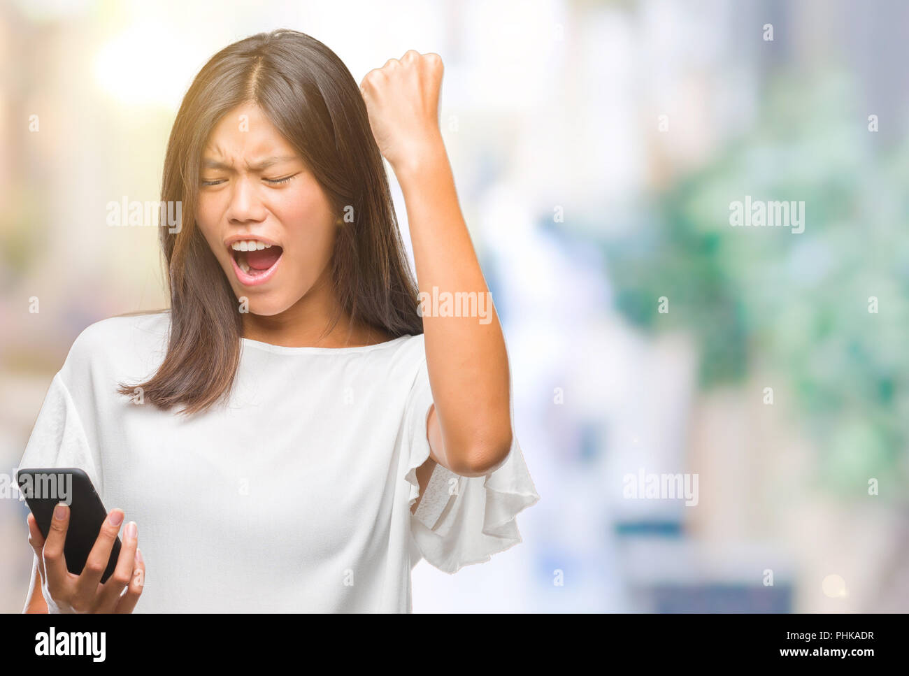 Young asian woman texting using smartphone over isolated background ...
