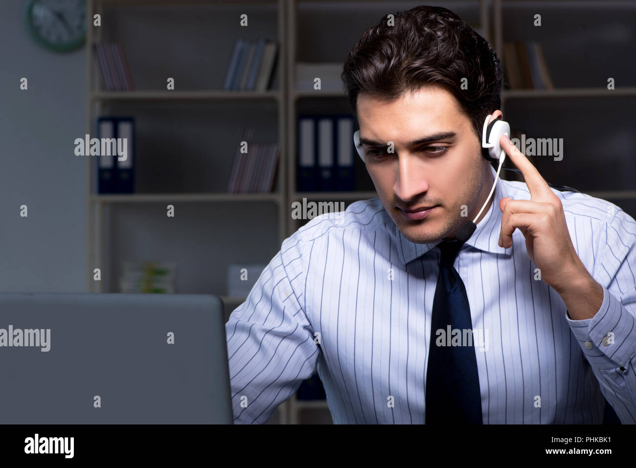 Call center operator talking to customer during night shift Stock Photo ...