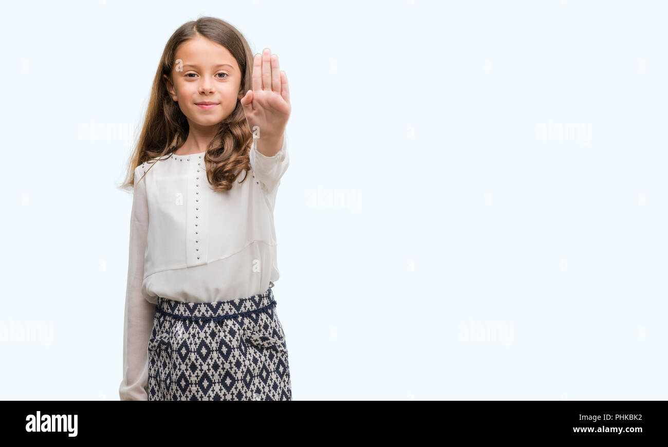 Brunette hispanic girl doing stop sing with palm of the hand. Warning ...