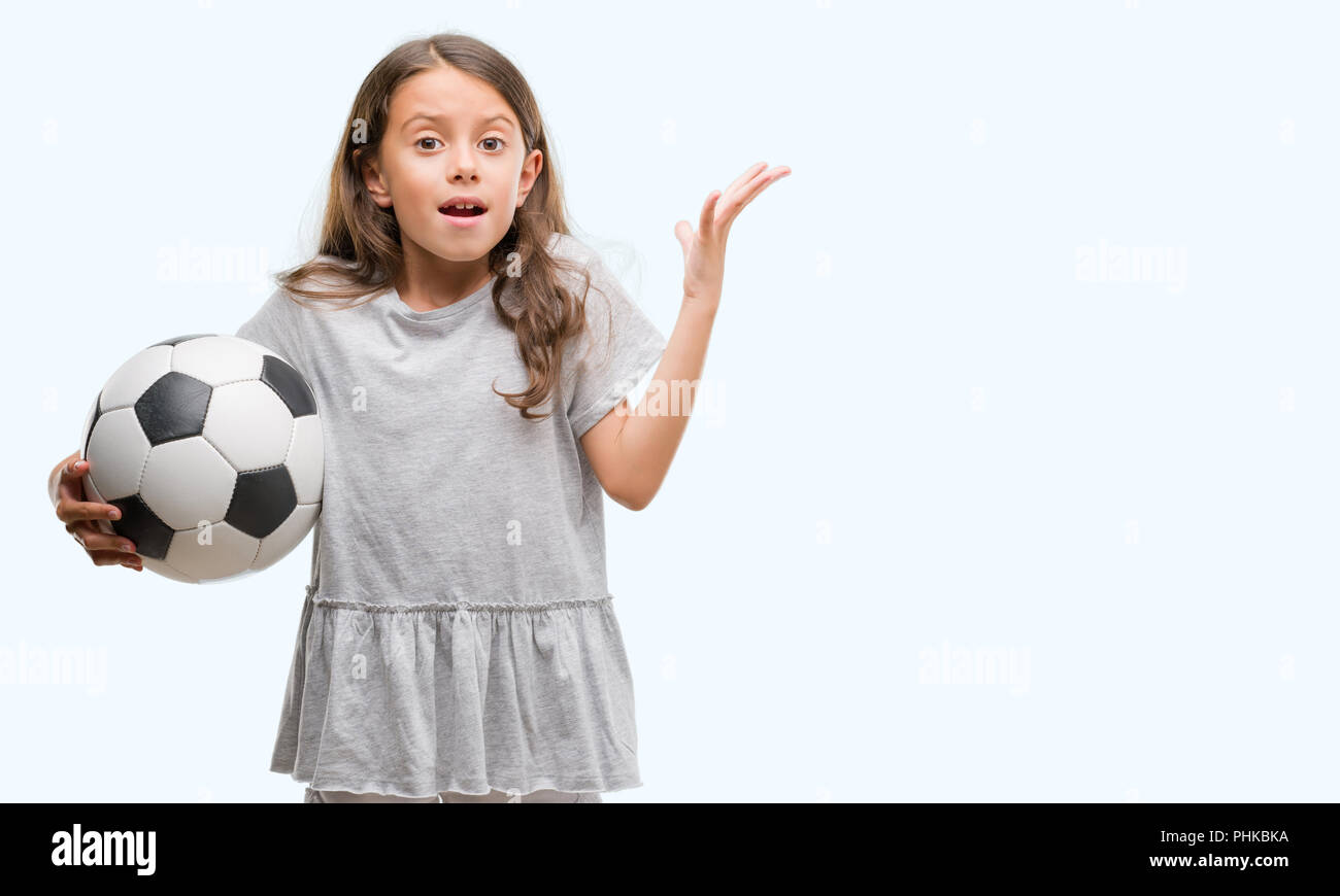 Brunette hispanic girl holding soccer football ball very happy and ...