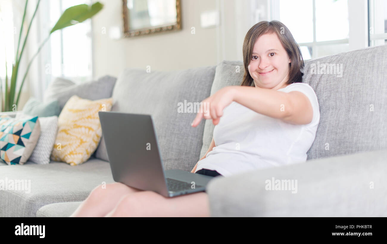 Down syndrome woman at home using computer laptop very happy pointing ...
